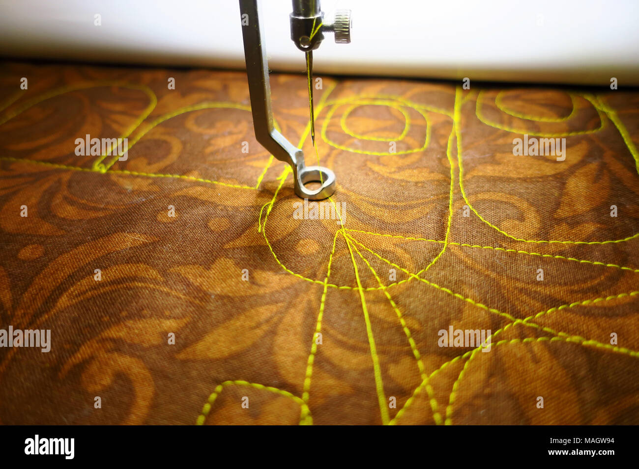 An embroidery machine stitching thread into a pattern Stock Photo - Alamy
