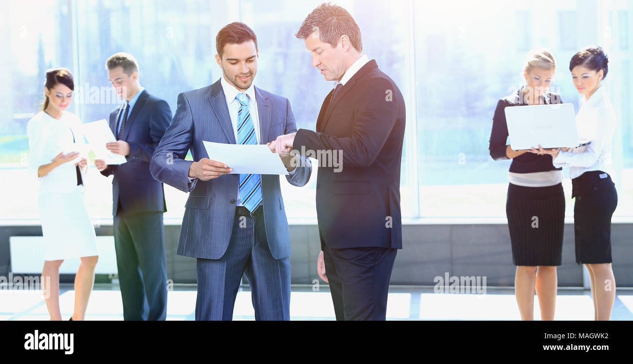employees discuss working papers, standing in the lobby Stock Photo - Alamy