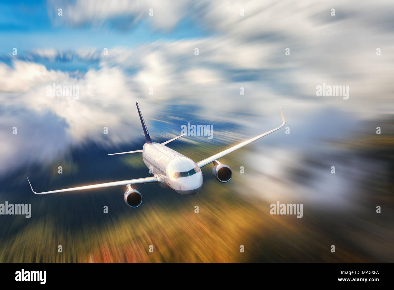 Modern airplane with motion blur effect is flying in low clouds at ...