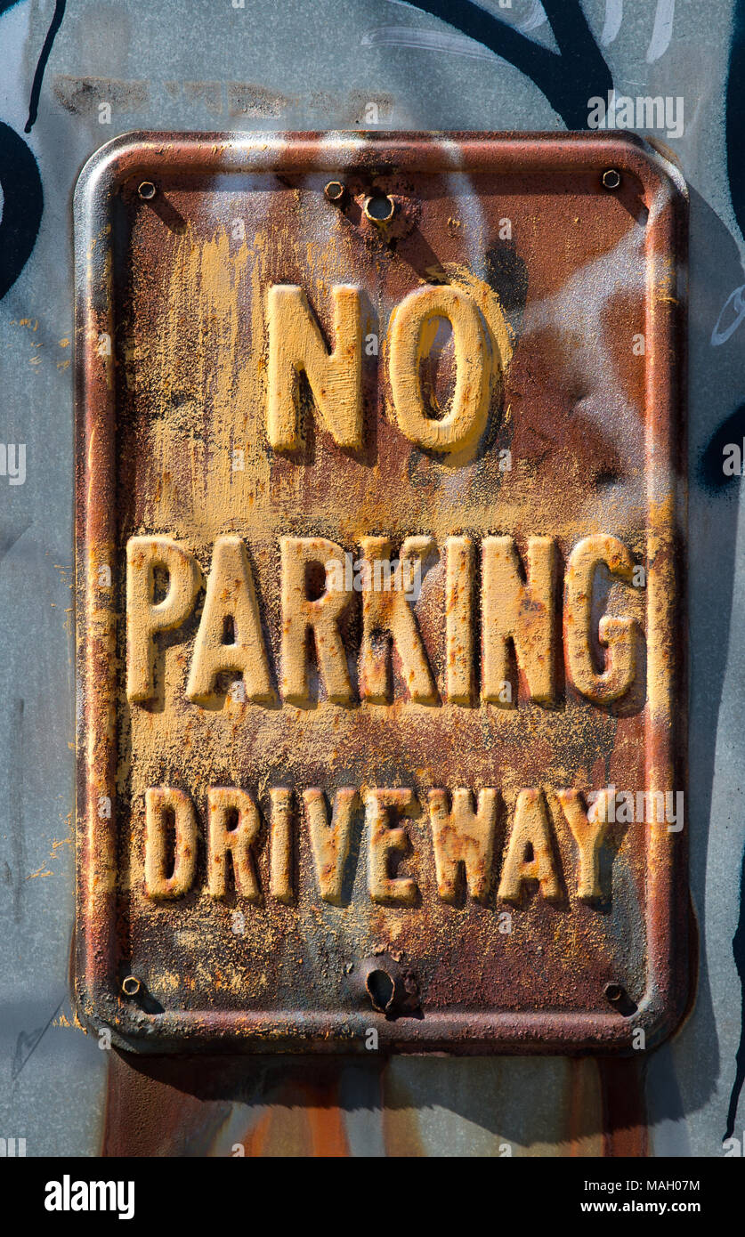 Rusted, vintage No Parking in Driveway sign Stock Photo - Alamy