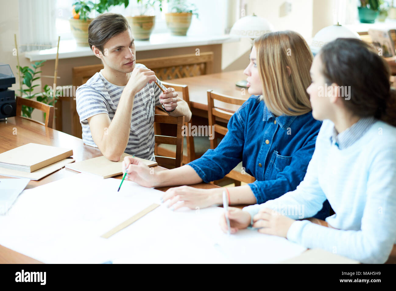 Introspective students drawing sketch together Stock Photo - Alamy