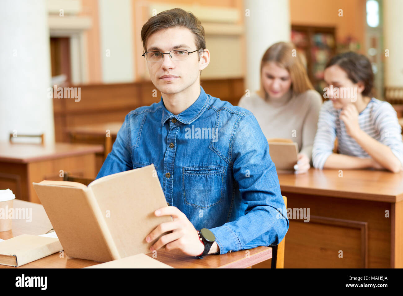 Ambitious university student spending time in library Stock Photo - Alamy