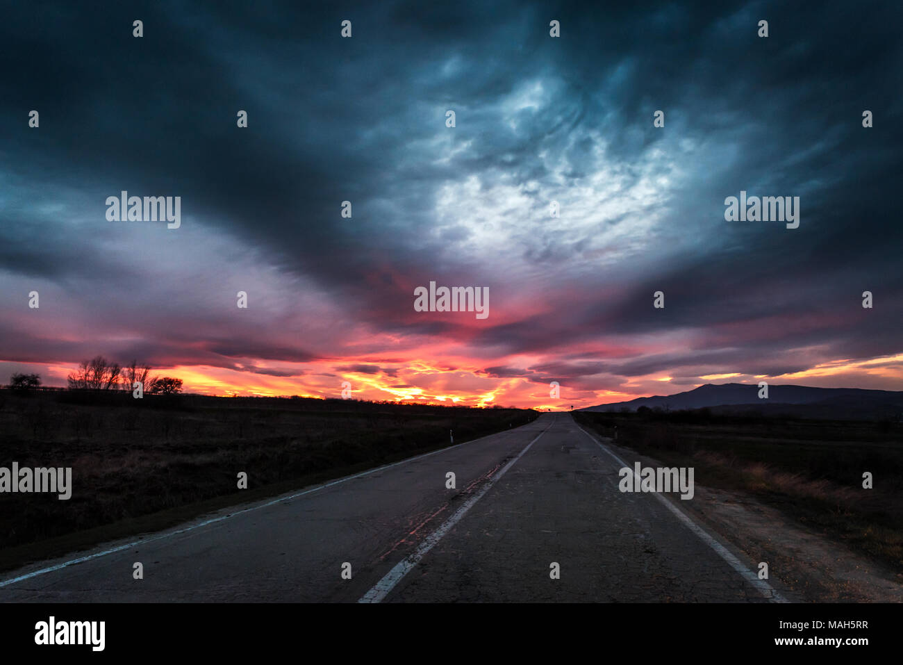 Straight highway road to a dramatic fiery sunset near twilight Stock ...