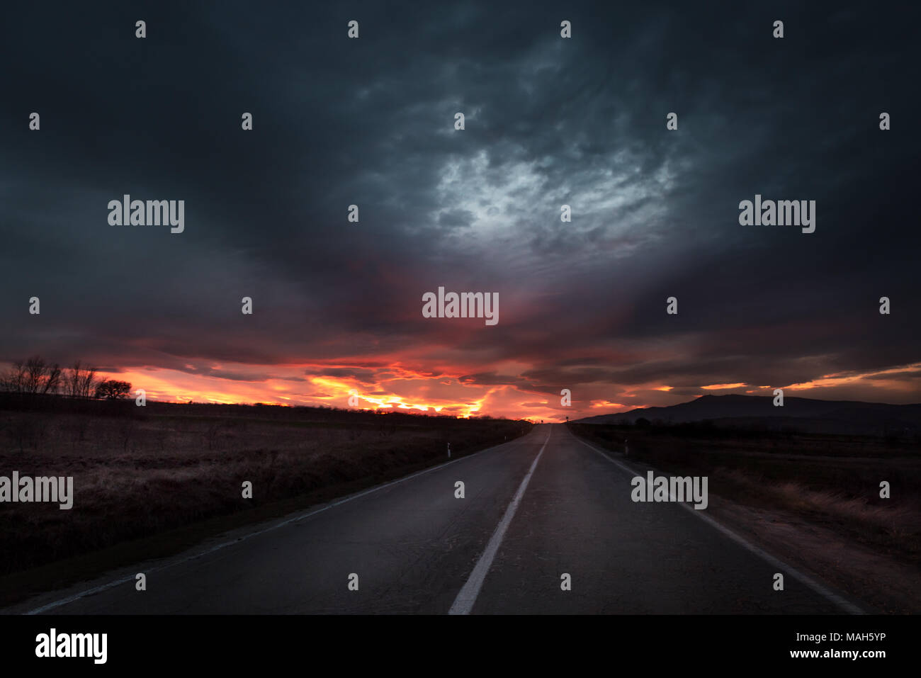 Straight highway road to a dramatic fiery sunset near twilight Stock ...