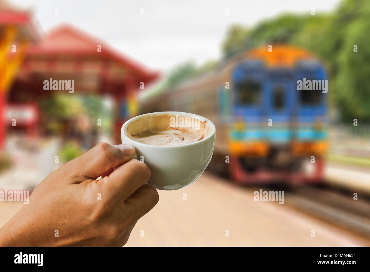 cup of coffee in the hands on train station background Stock Photo - Alamy