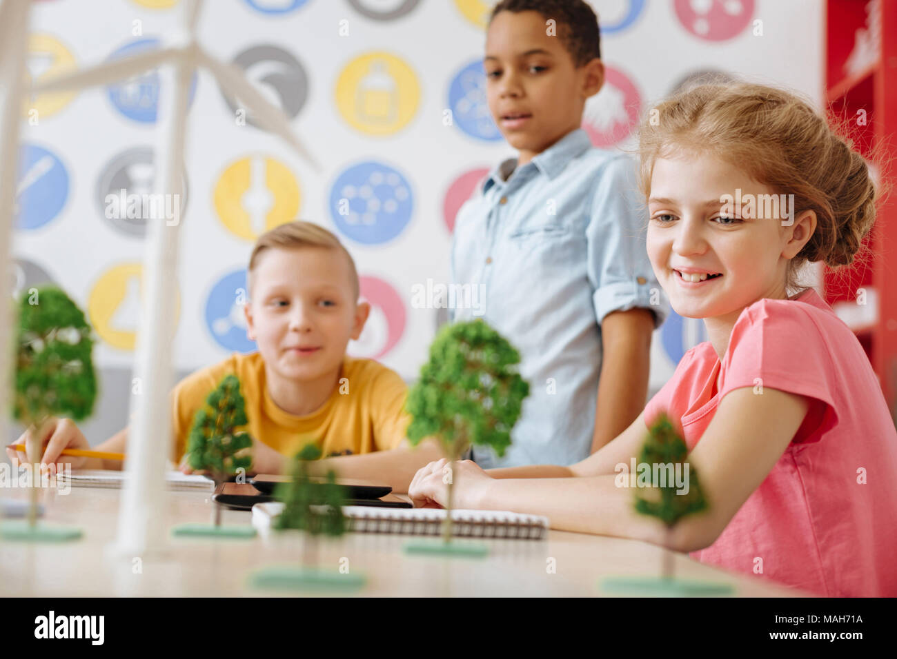 Pleasant girl looking at tree models with smile Stock Photo - Alamy