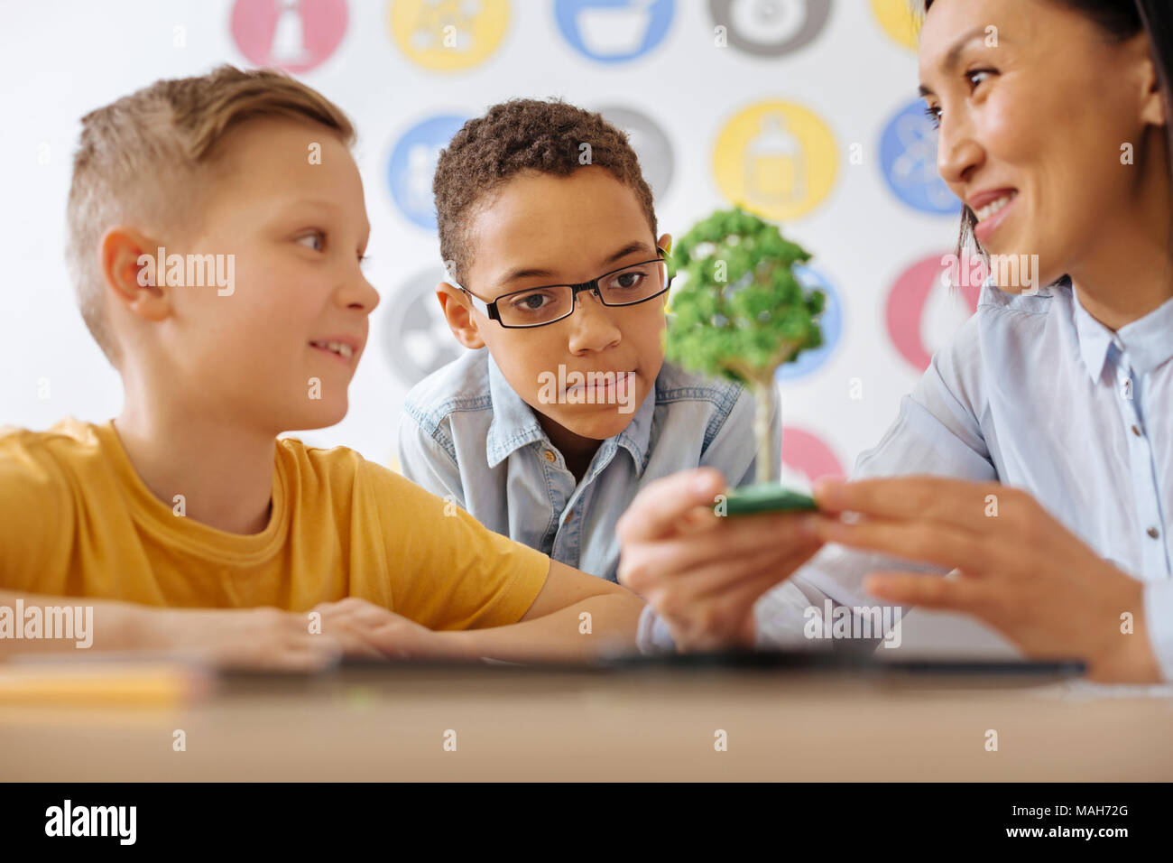 Cheerful teacher showing tree model to her students Stock Photo - Alamy