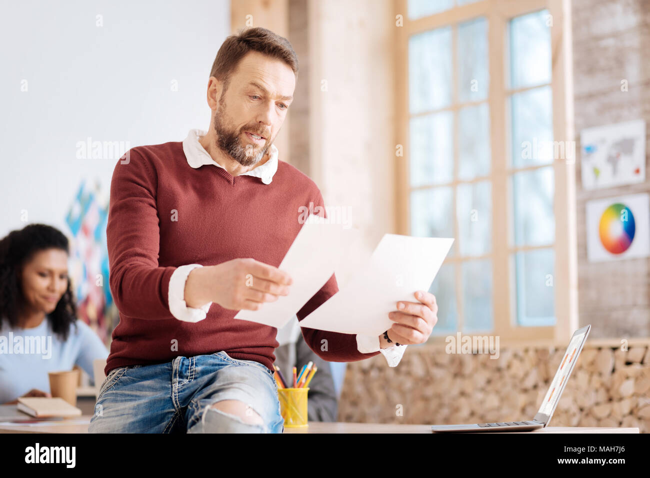 Serious holding sheets of paper Stock Photo - Alamy