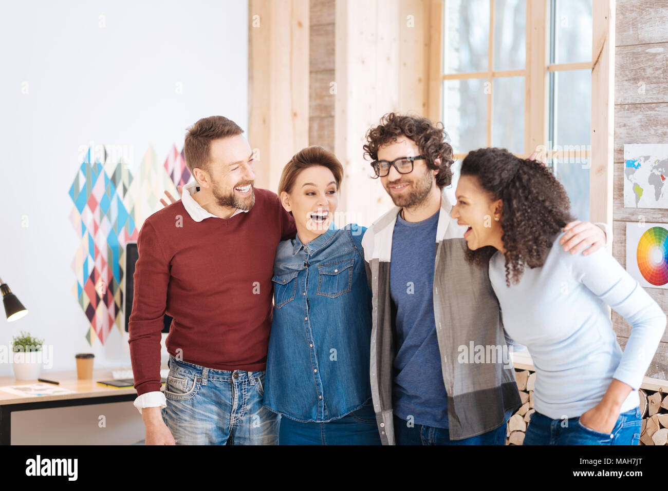 Happy employees smiling and hugging Stock Photo - Alamy