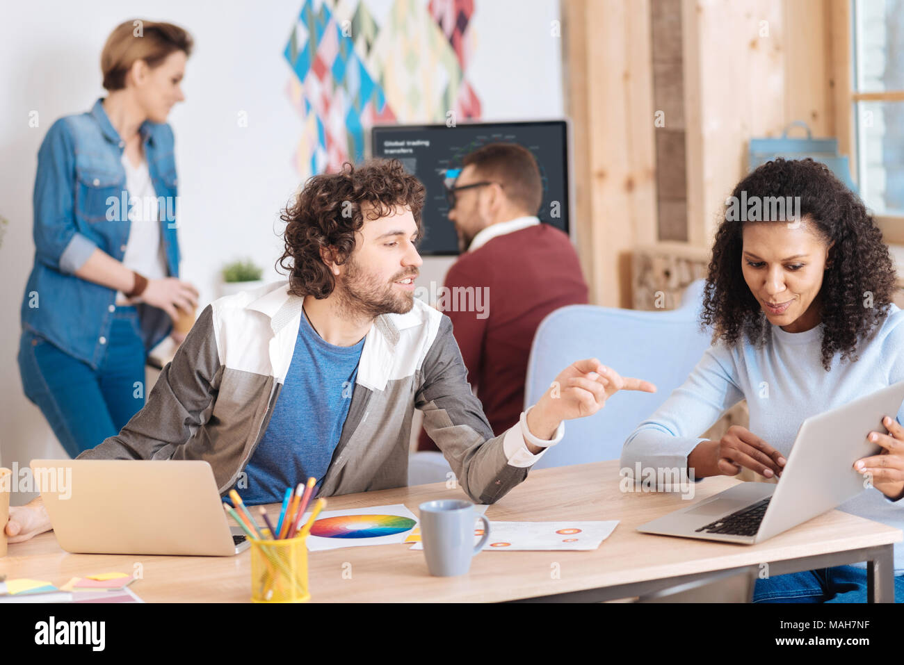 Happy colleagues working together on a project Stock Photo - Alamy