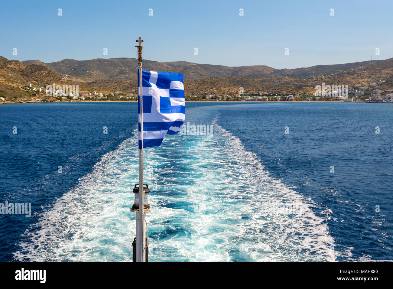 National Greek flag and water trail foaming behind a ferry boat ...