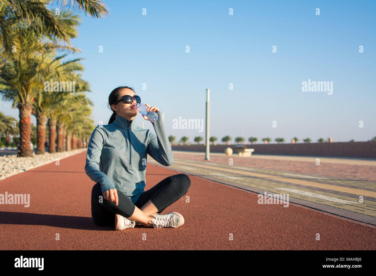 Girl taking a break from workout on a running track Stock Photo - Alamy