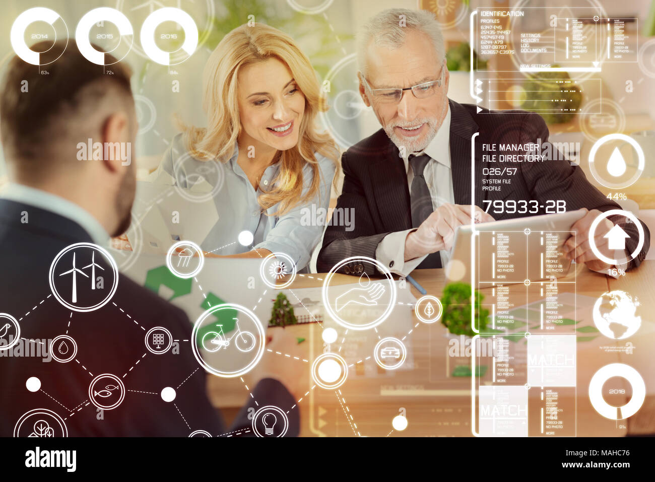 Cheerful engineers looking at the screen of a tablet and feeling glad ...