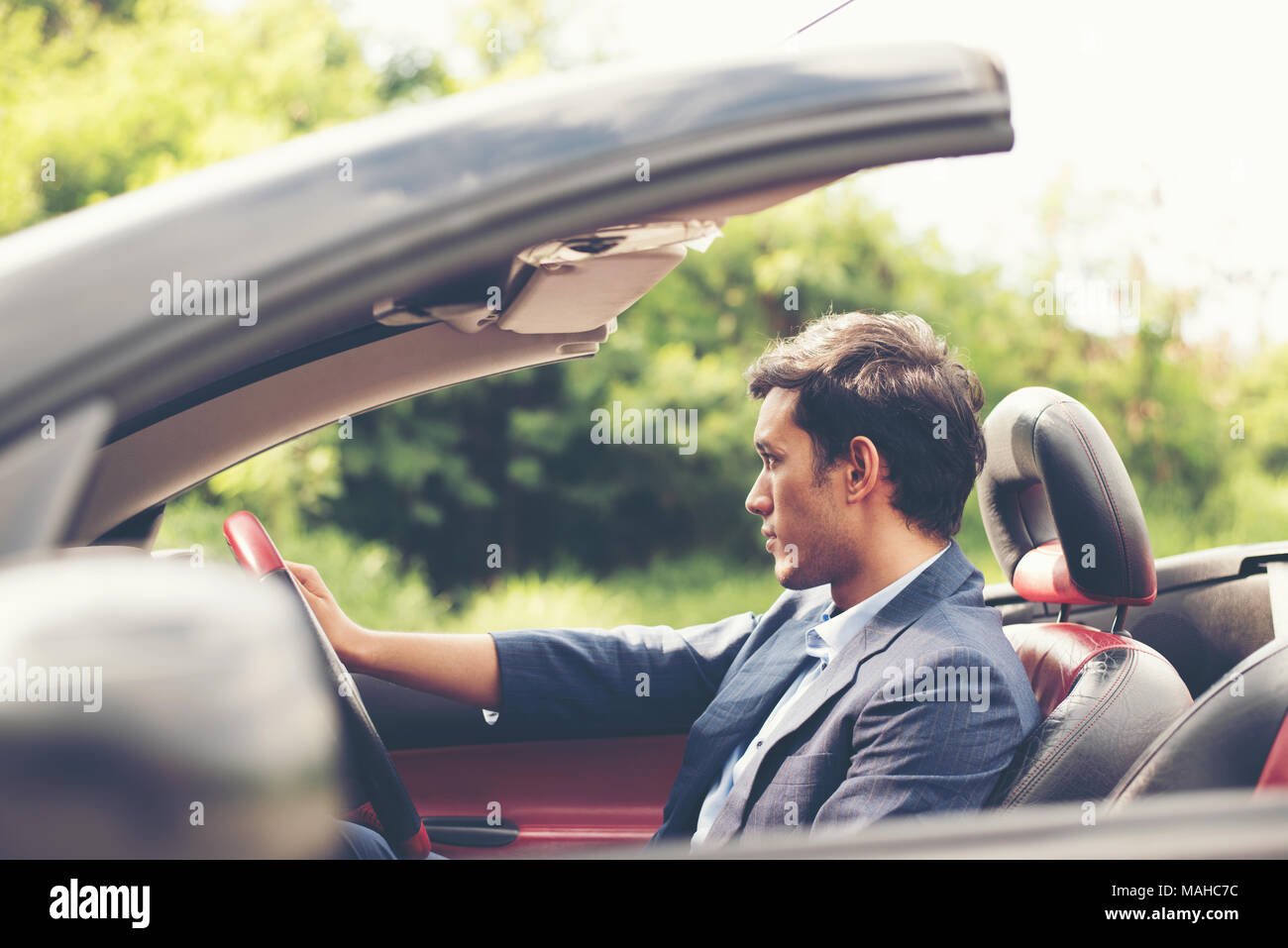 Handsome young man in sports car wearing suit Stock Photo - Alamy
