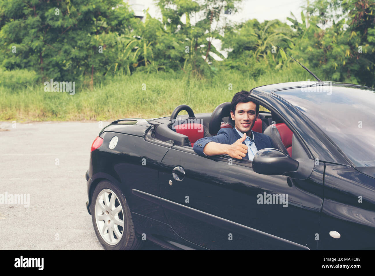 Handsome young man in sports car wearing suit Stock Photo - Alamy