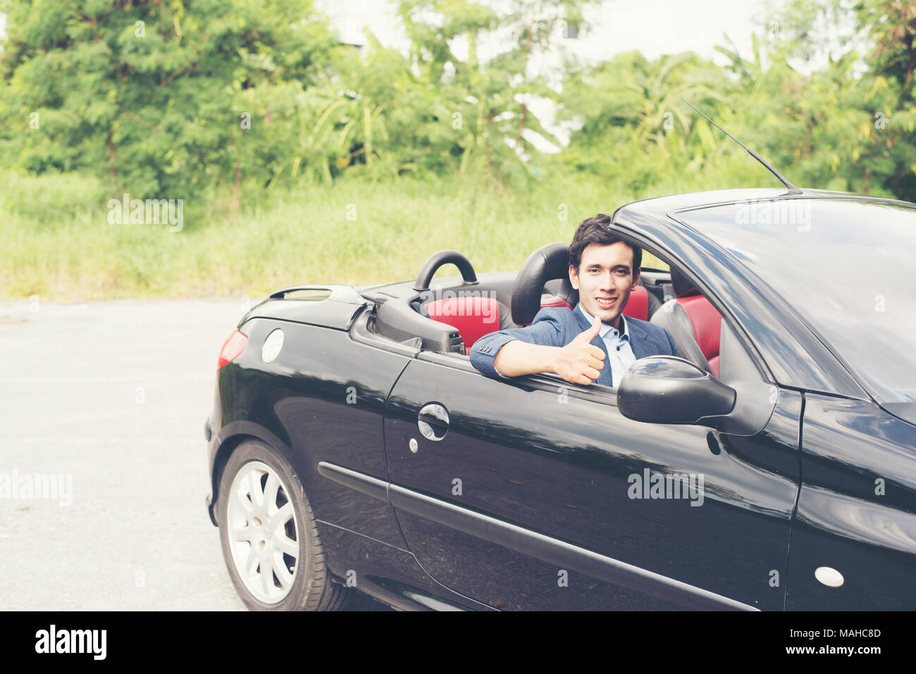 Handsome young man in sports car wearing suit Stock Photo - Alamy