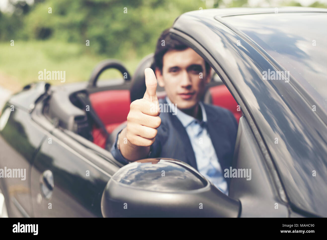 Handsome young man in sports car wearing suit Stock Photo - Alamy