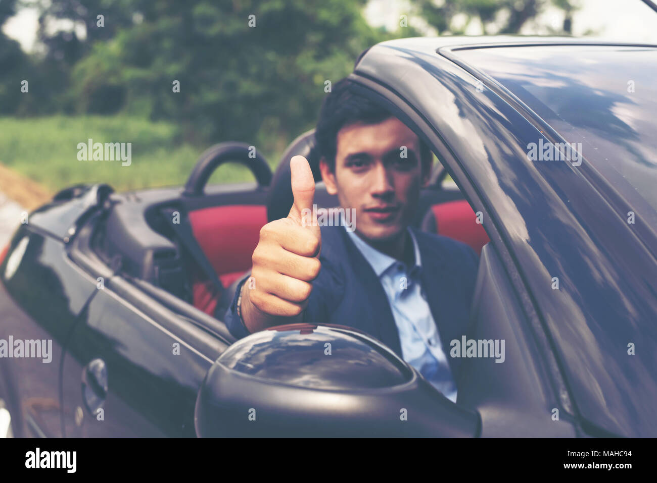 Handsome young man in sports car wearing suit Stock Photo - Alamy