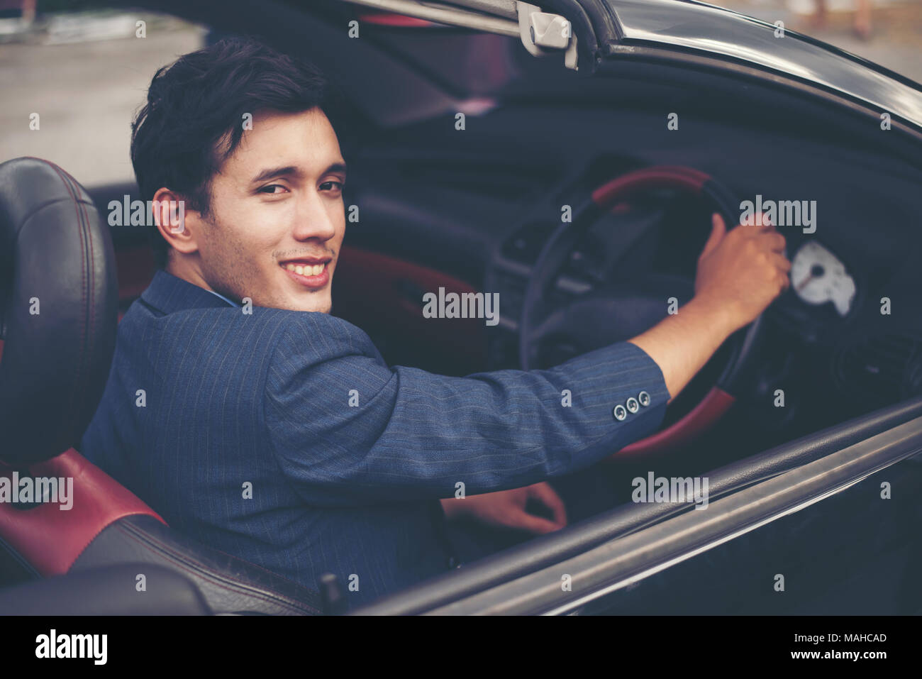 Handsome young man in sports car wearing suit Stock Photo - Alamy