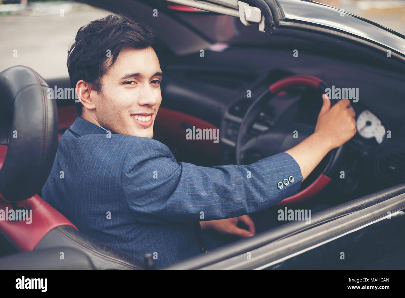 Handsome young man in sports car wearing suit Stock Photo - Alamy