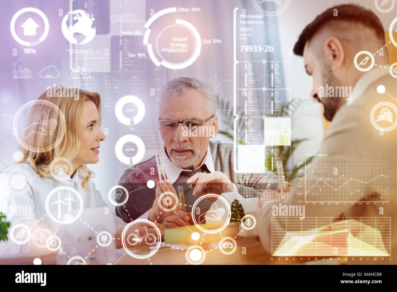 Serious engineer comparing samples while sitting with colleagues Stock ...