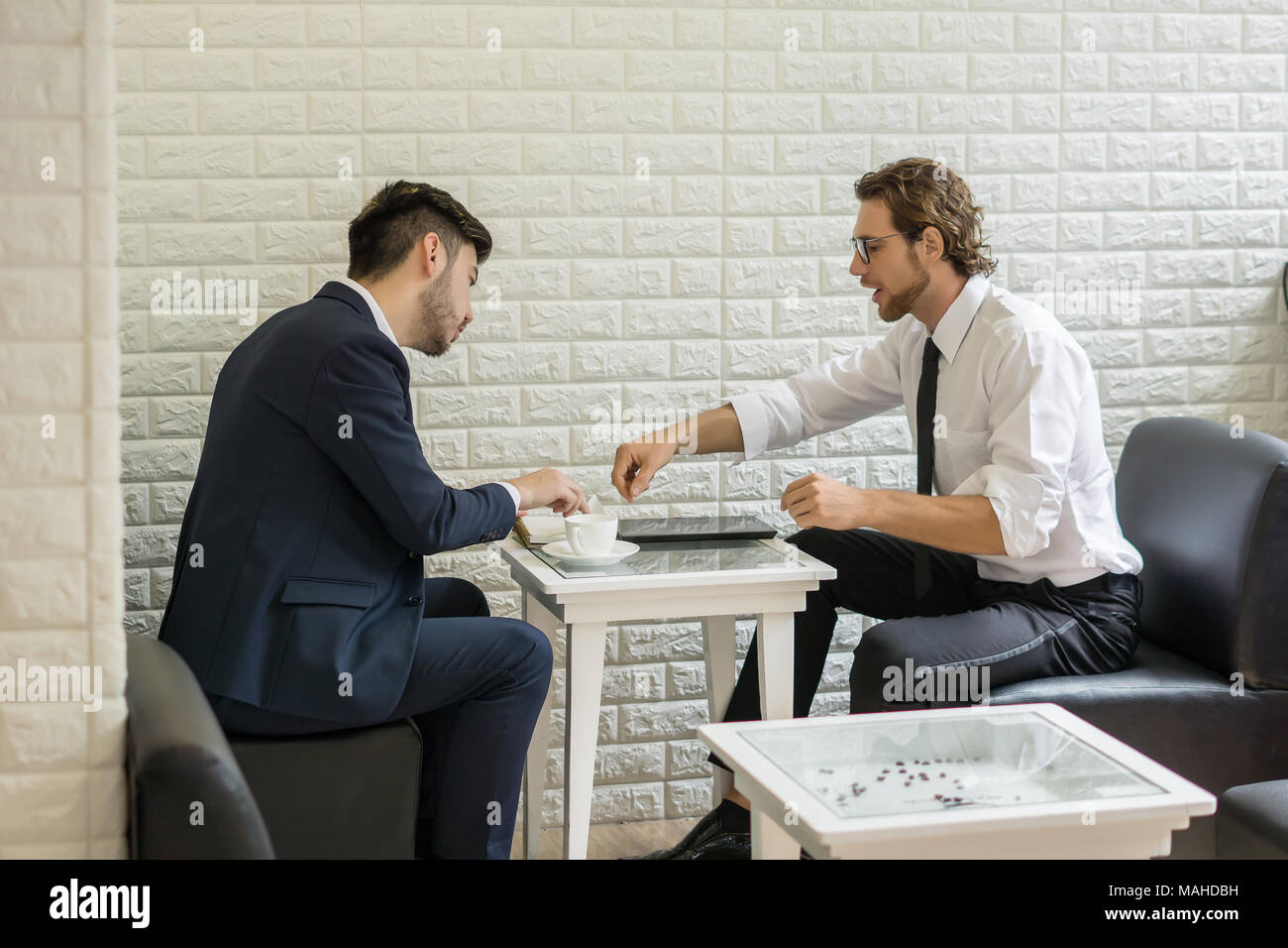 Young businessman talking work with colleague in a modern business ...