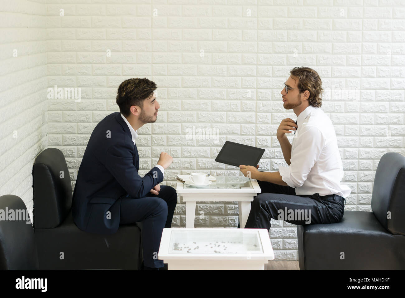 Young businessman talking work with colleague in a modern business ...