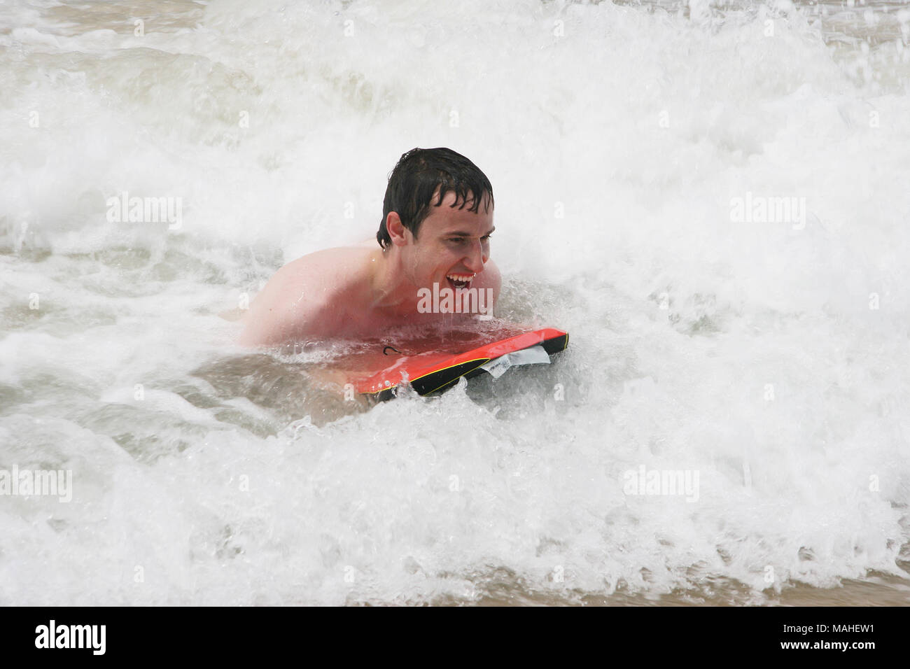 Young white male laughing while bodyboarding Stock Photo - Alamy