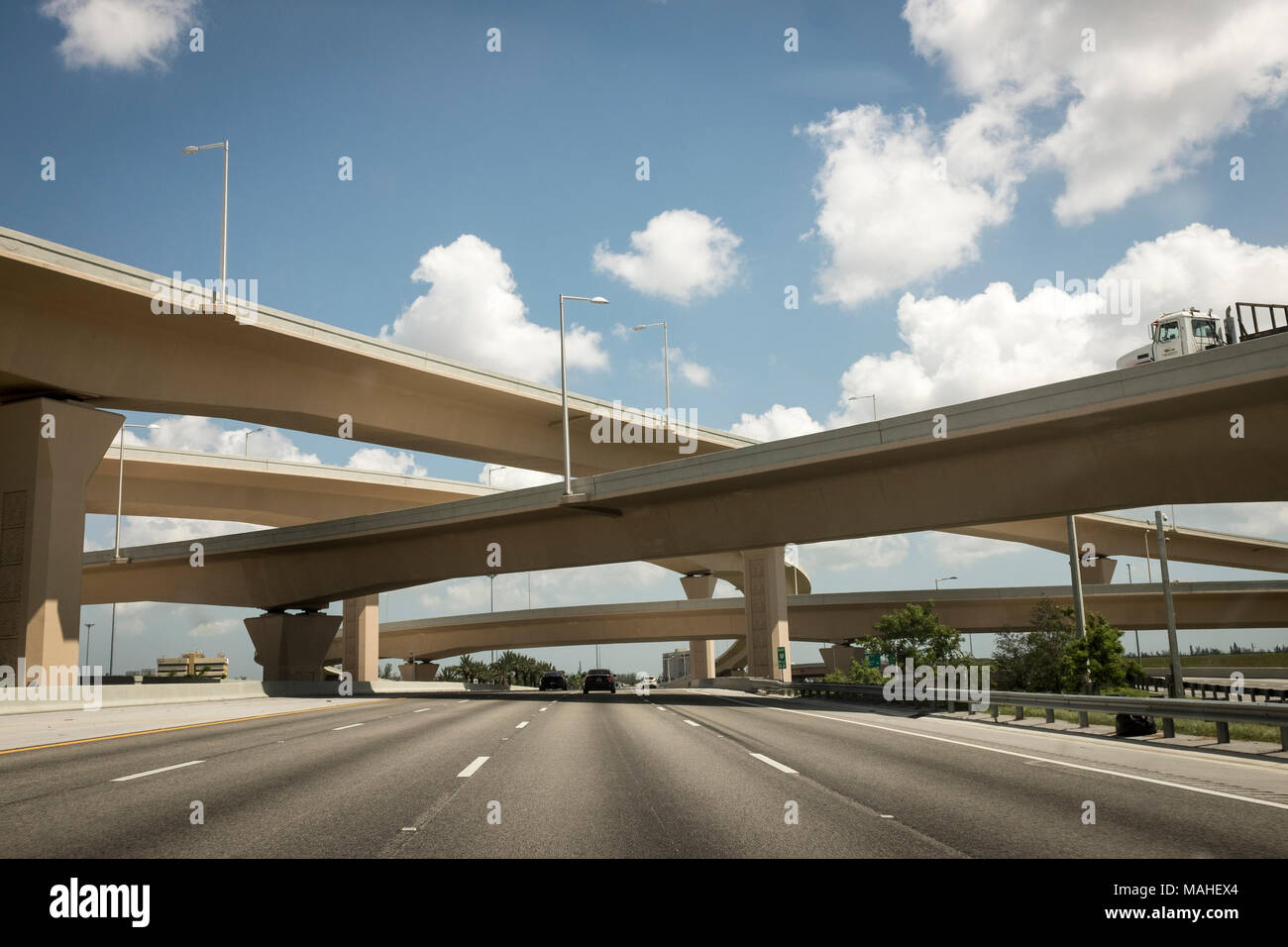 Vehicles traveling below and over overpass along multi lane highway ...
