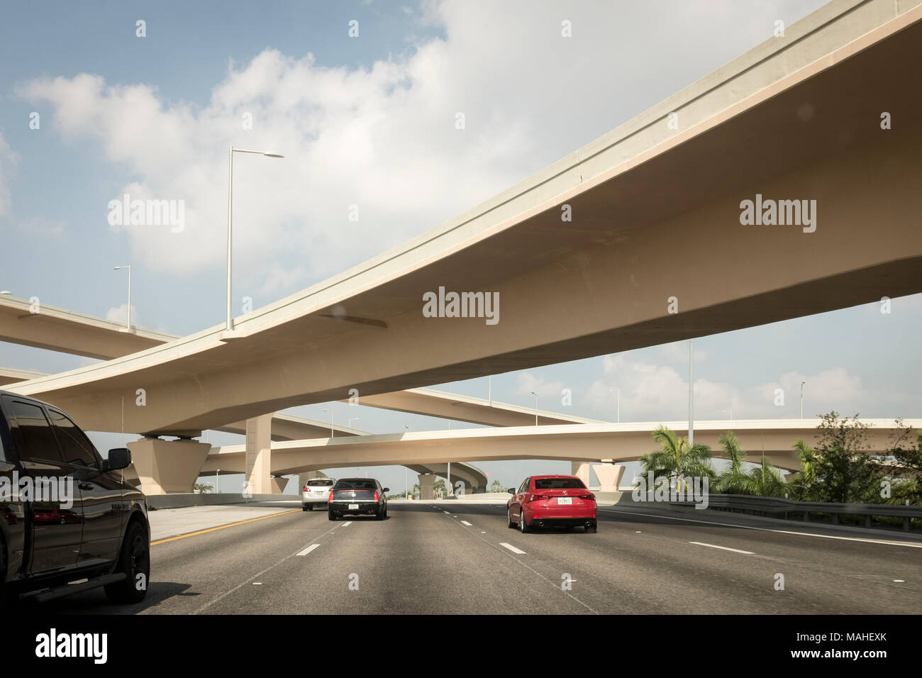 Cars traveling under overpass along multi lane highway Stock Photo - Alamy