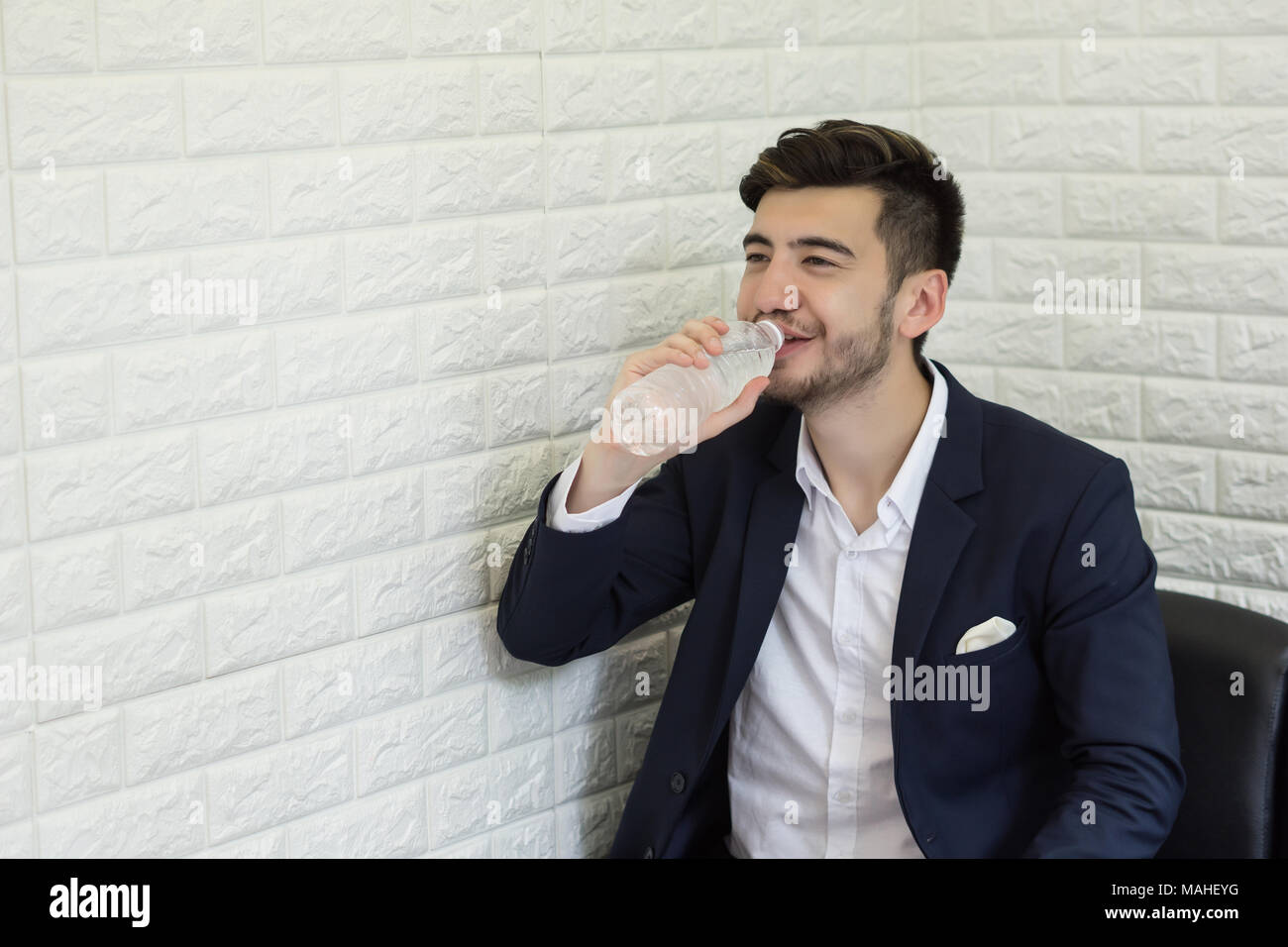 Young businessman drinking water at office Stock Photo - Alamy