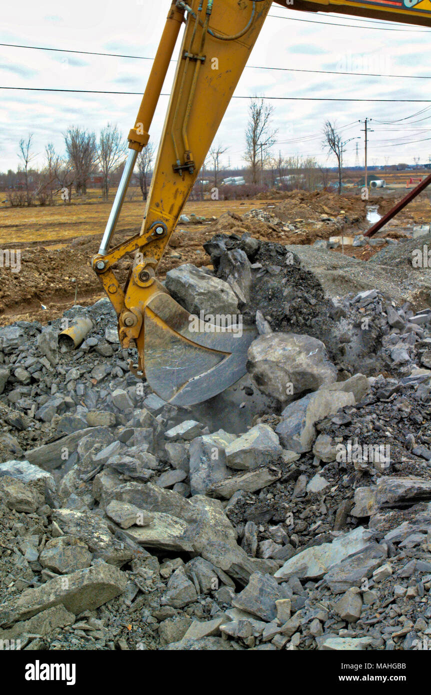 Excavator shovel digging rock on constriction site Stock Photo - Alamy