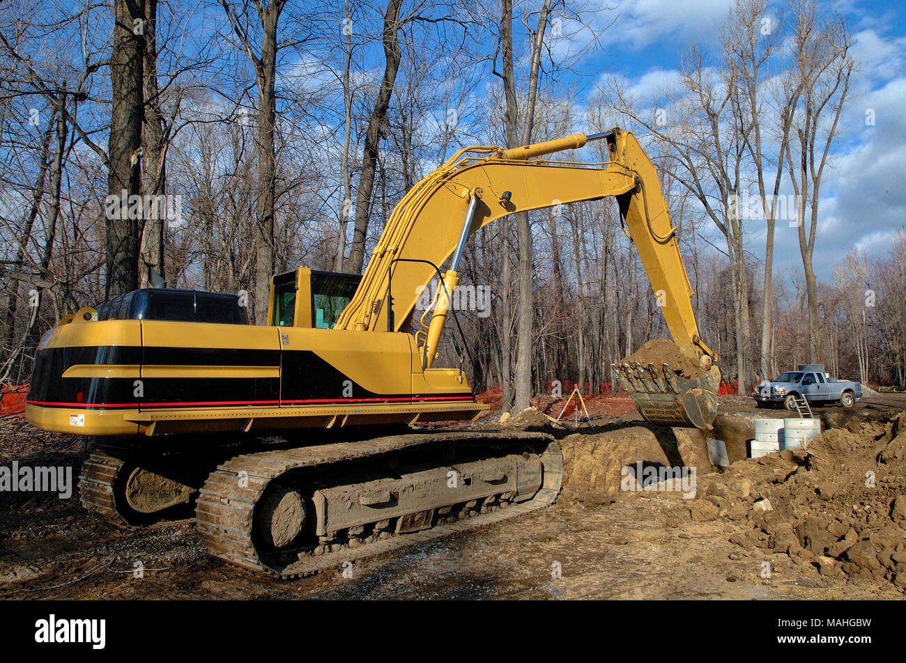 Excavator digging a deep trench, working Stock Photo - Alamy