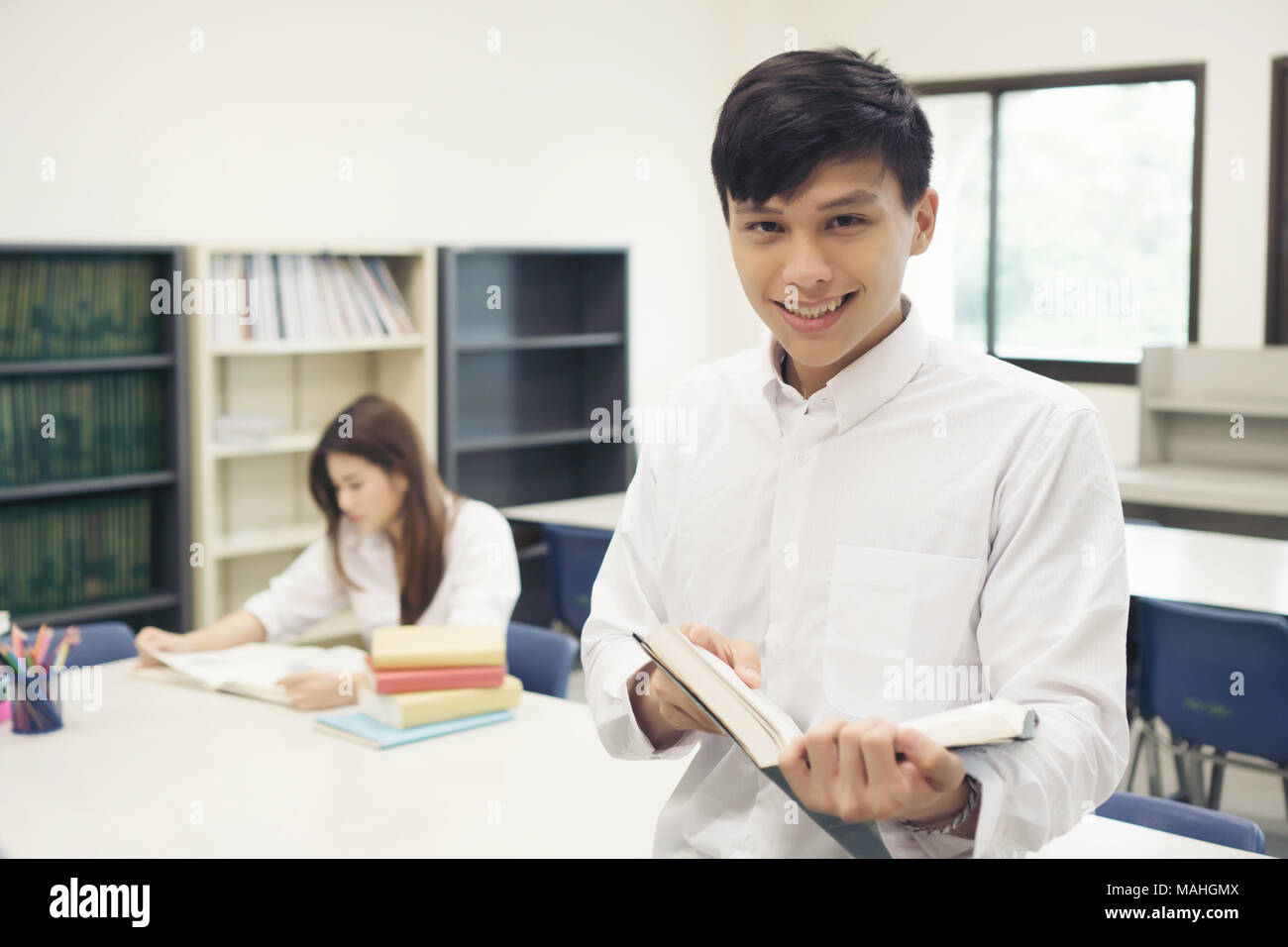 Young student reading book in library . Education concept Stock Photo ...