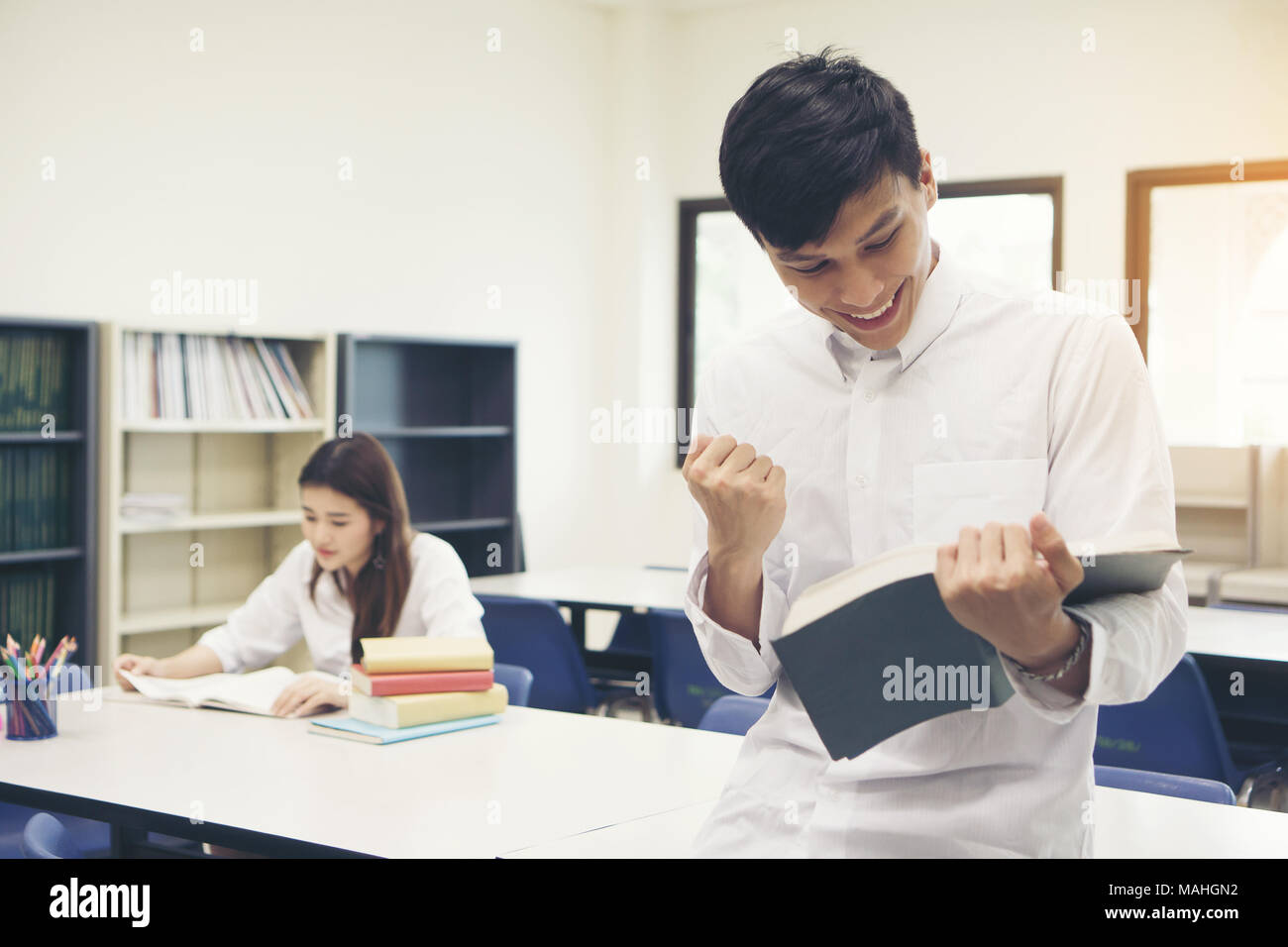 Young student reading book in library . Education concept Stock Photo ...