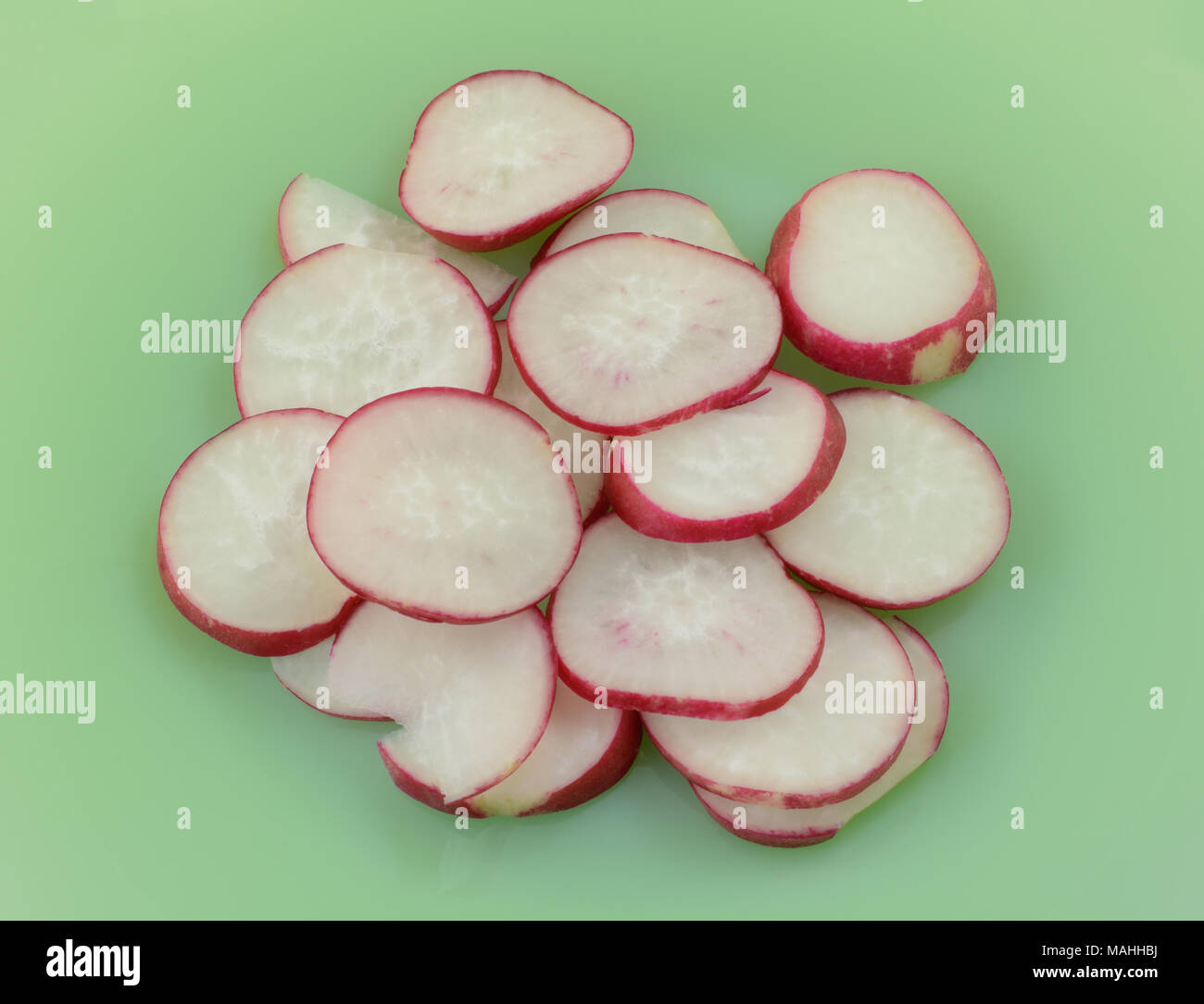 Raw radish slices on green plate as ingredient to add during meal ...