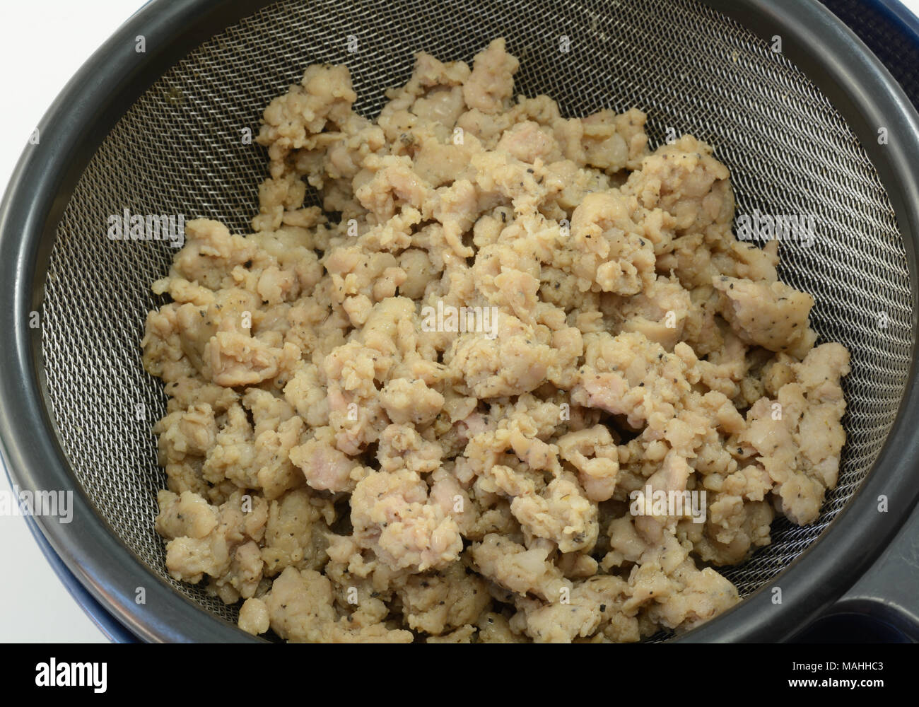Cooked Italian pork sausage crumbles in strainer to drain excess grease ...