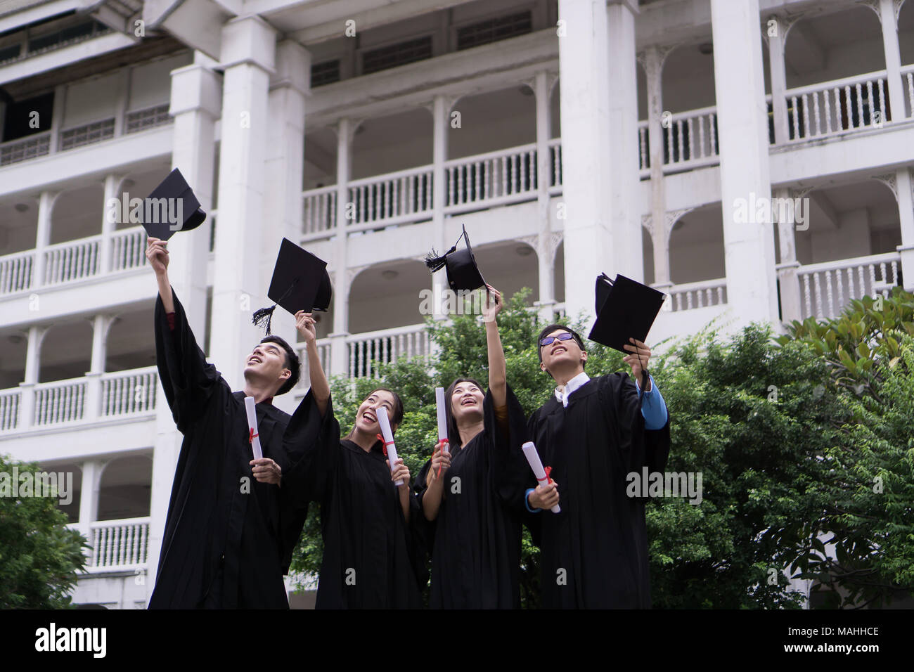 Group of Successful students with congratulations together throwing ...