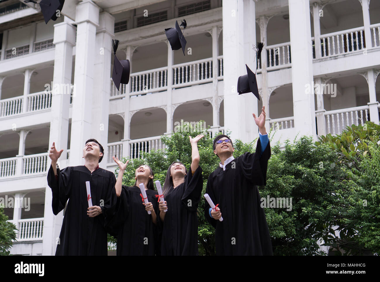 Group of Successful students with congratulations together throwing ...