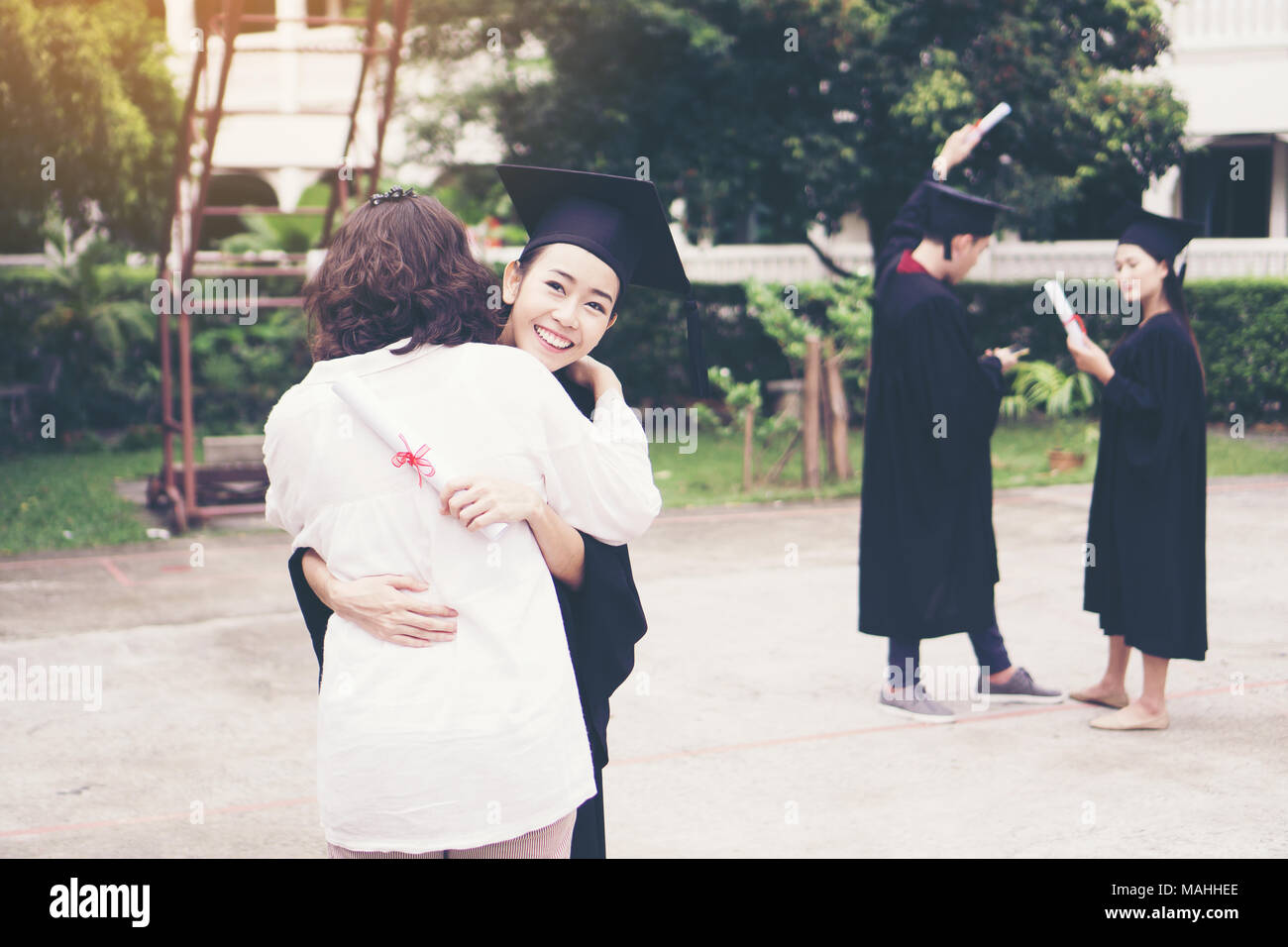 Young female graduate hugging her mother at graduation ceremony ...