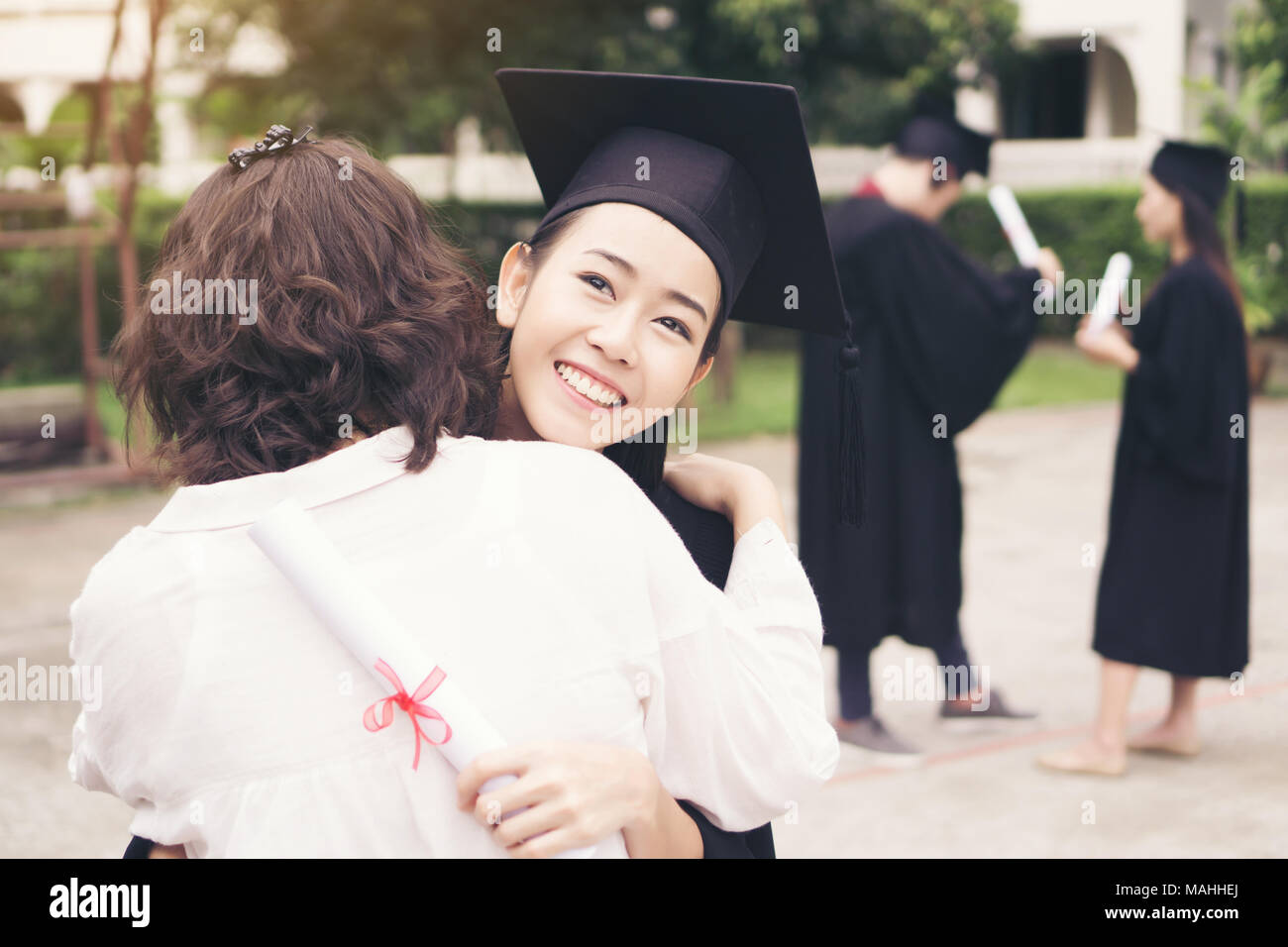 Young female graduate hugging her mother at graduation ceremony ...