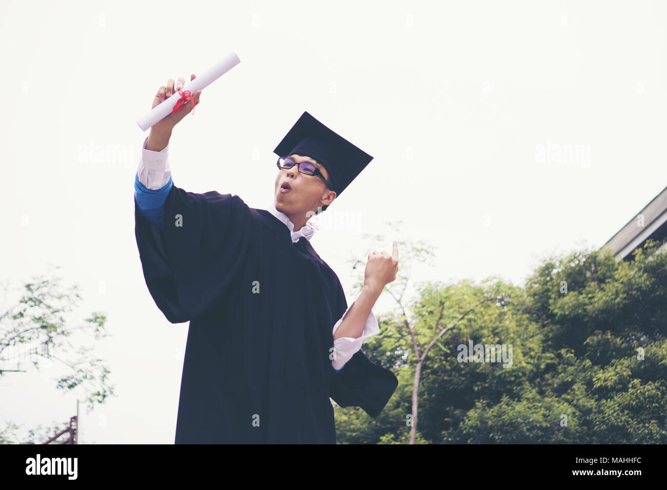 Happy graduate student holding a diploma in hand. Education concept ...