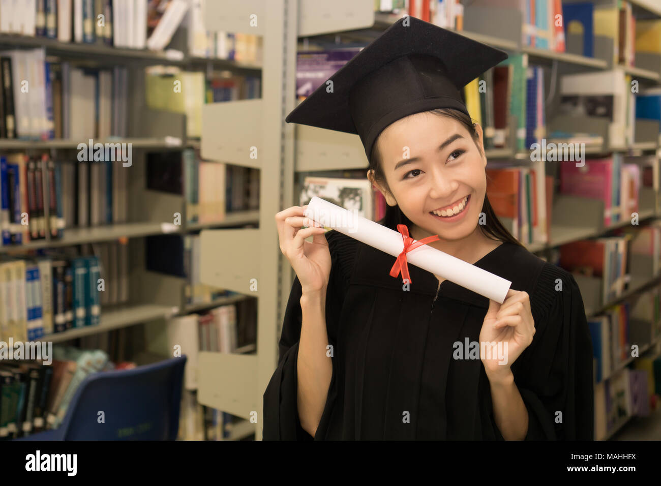 Happy graduate student holding a diploma in hand. Education concept ...