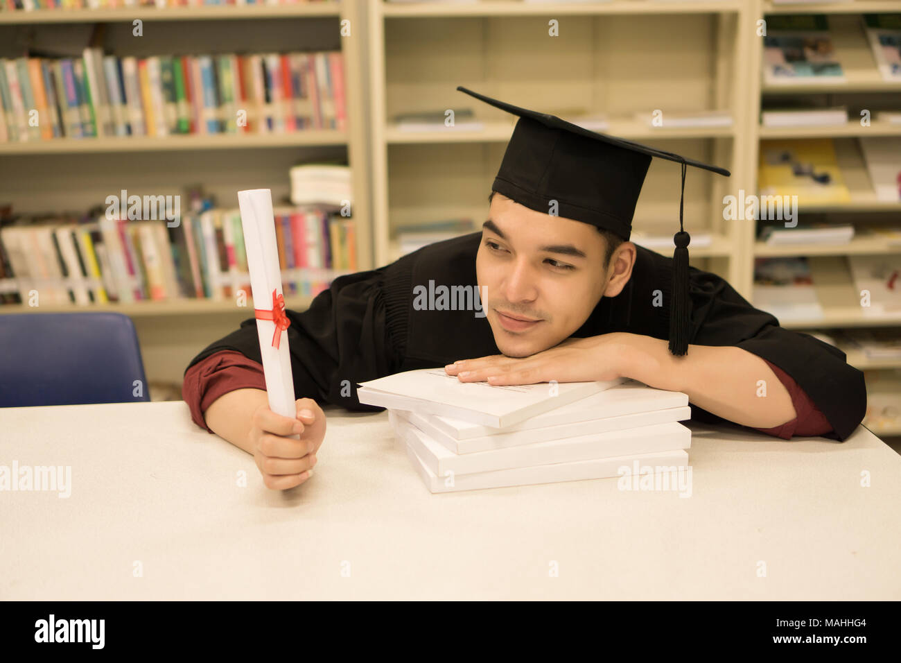 Happy graduate student holding a diploma in hand. Education concept ...