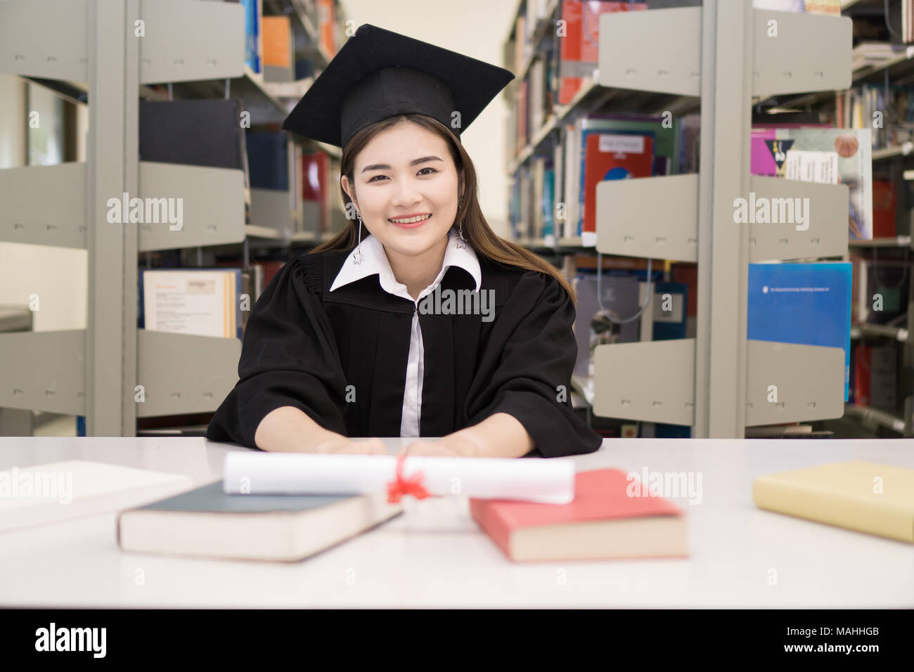 Happy graduate student holding a diploma in hand. Education concept ...