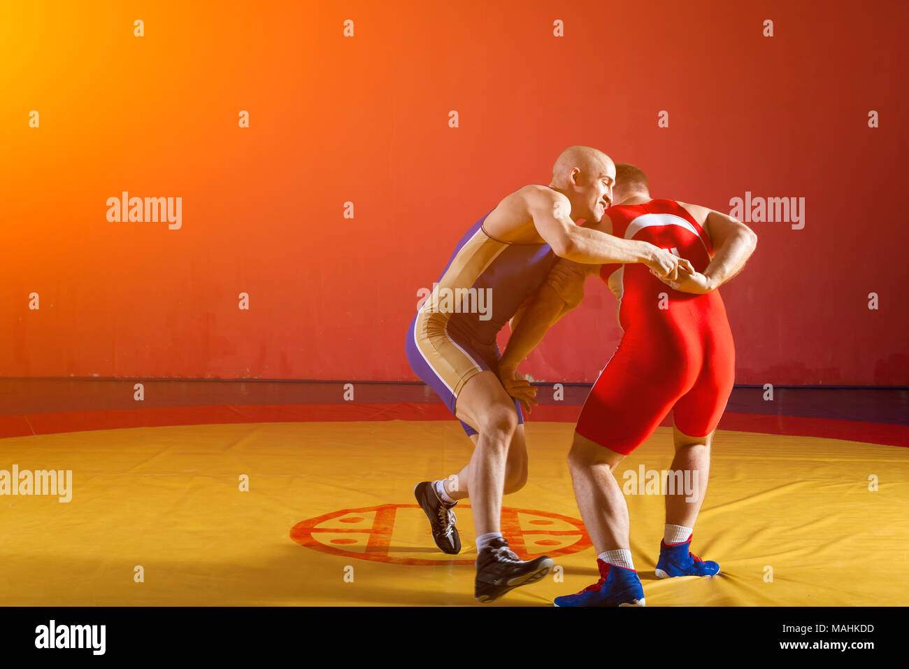Two greco-roman wrestlers in red and blue uniform making a suplex ...