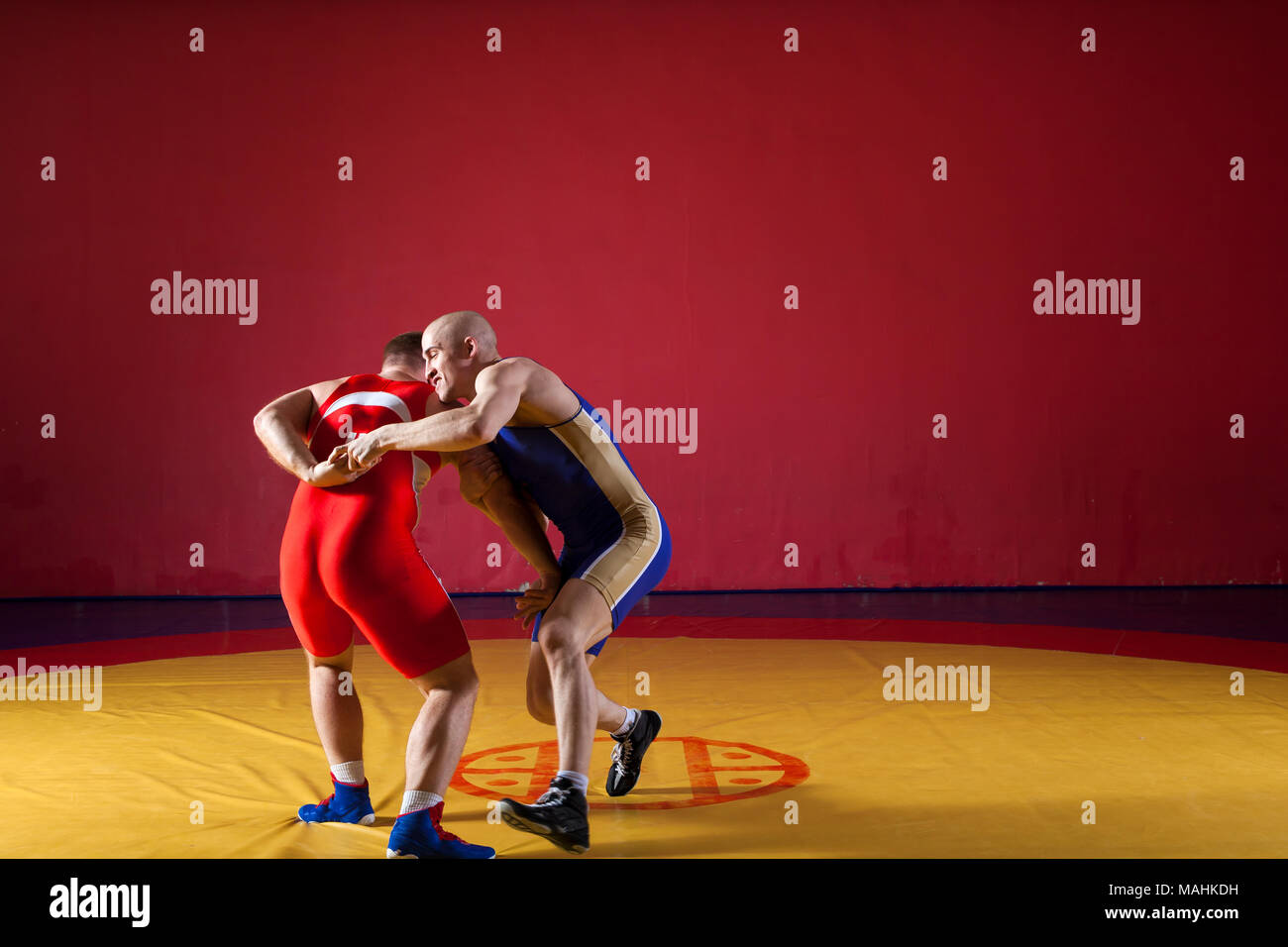 Two greco-roman wrestlers in red and blue uniform making a suplex ...