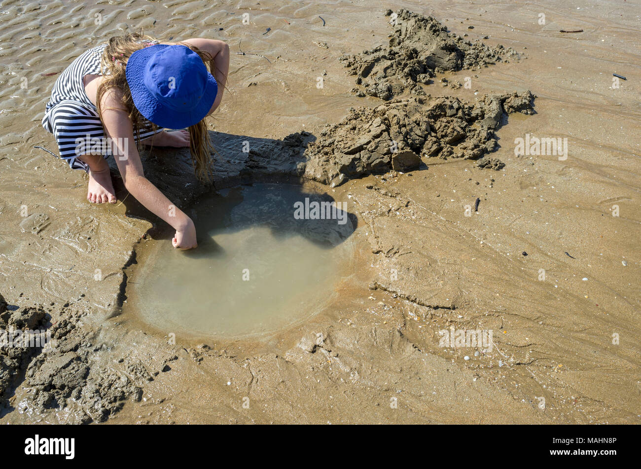 Child playing in a puddle at the beach Stock Photo - Alamy