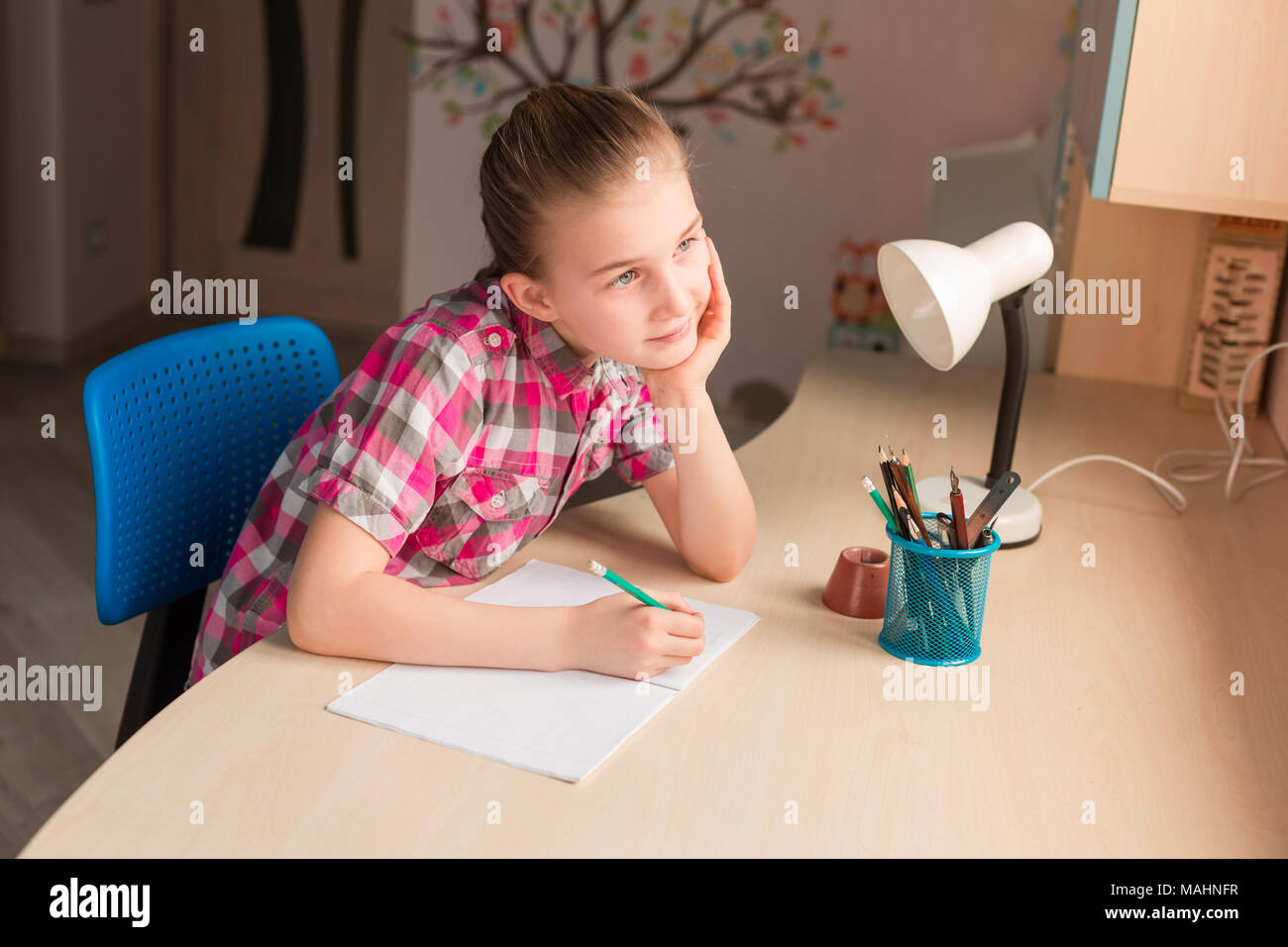 Cute little girl writing her homework at the table, left-handed Stock ...