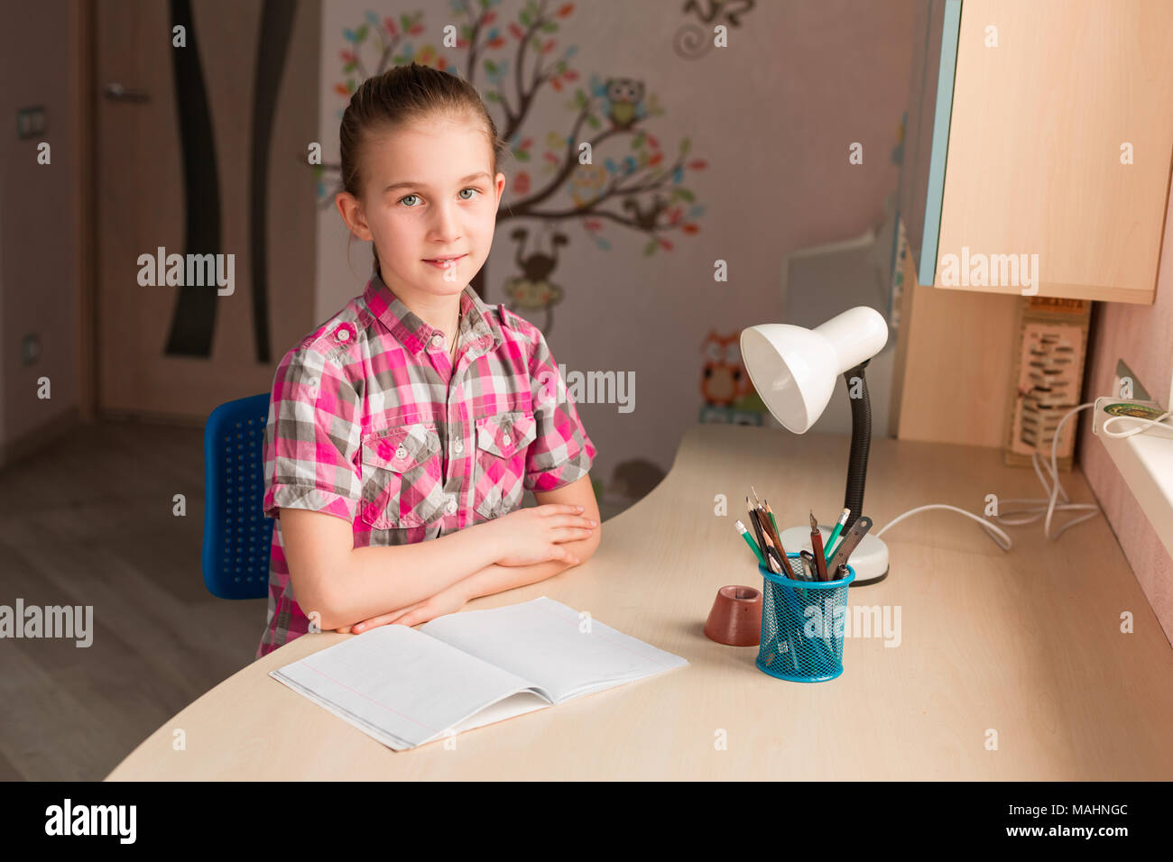 Cute little girl writing her homework at the table, left-handed Stock ...